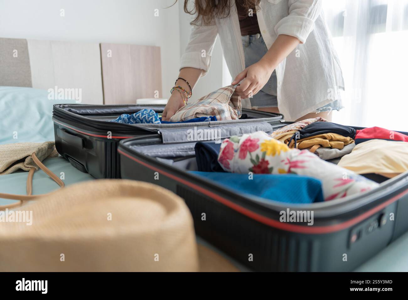 Woman packing suitcase on bed for a new journey packing list for travel ...