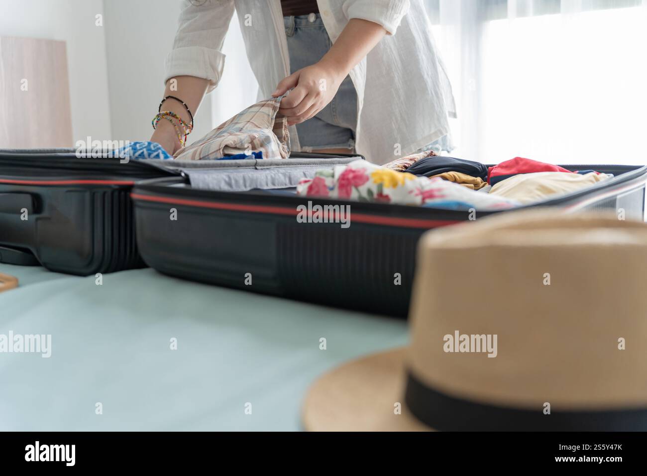 Woman packing suitcase on bed for a new journey packing list for travel ...