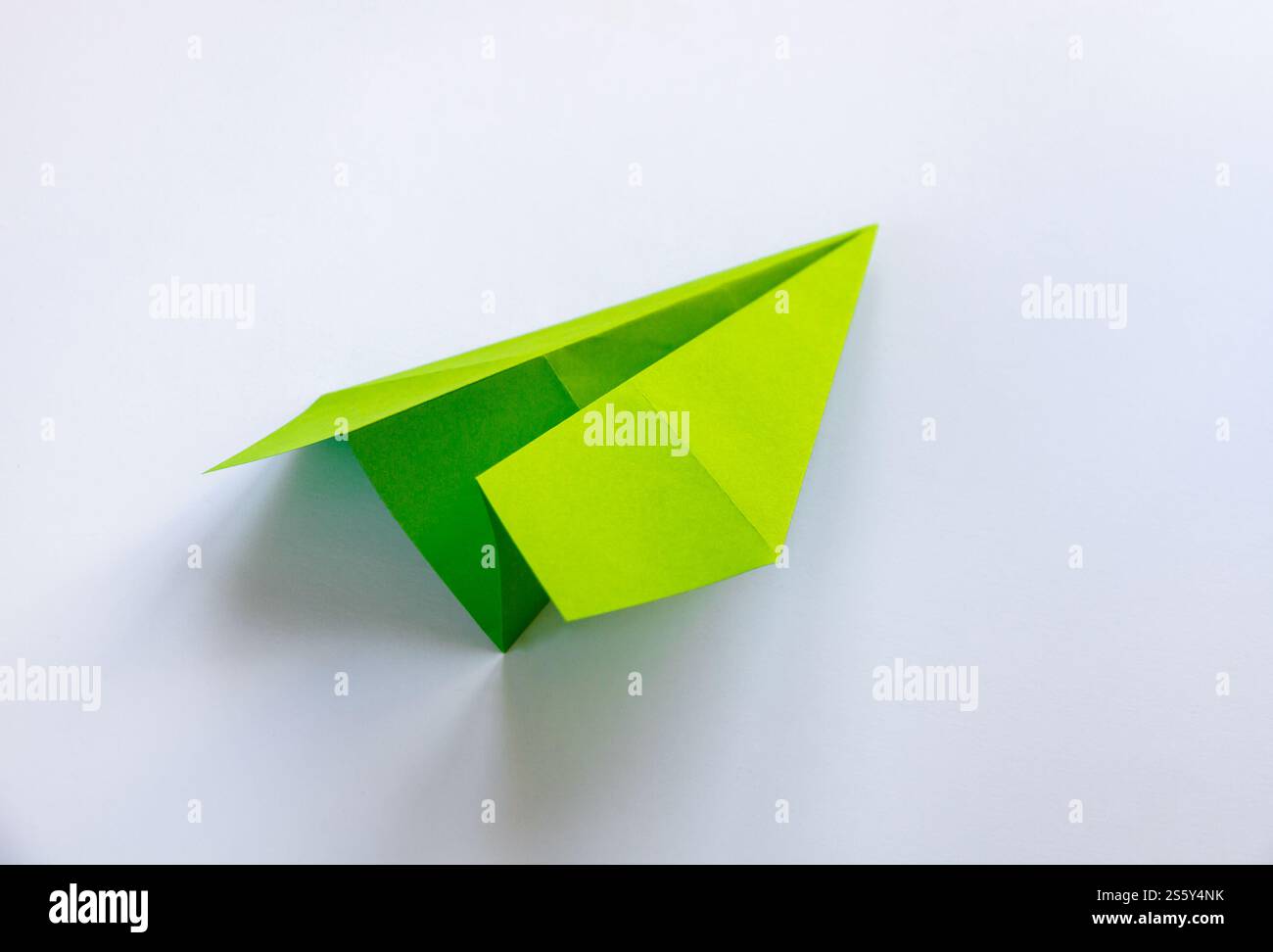 Green paper plane origami isolated on a blank white background. Green ...