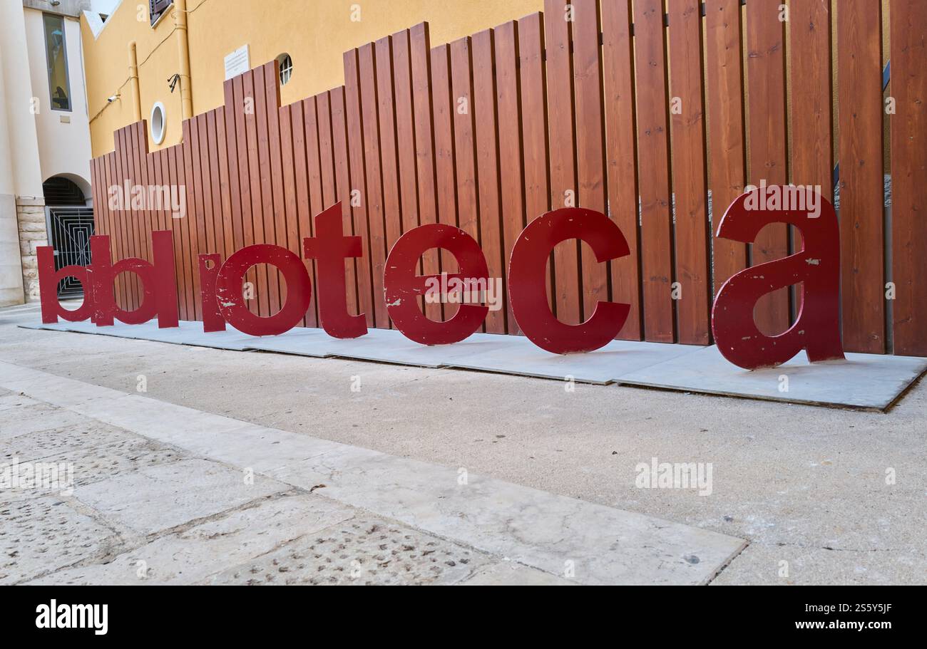 A detailed photograph shows the metallic ''Biblioteca'' sign on the ...
