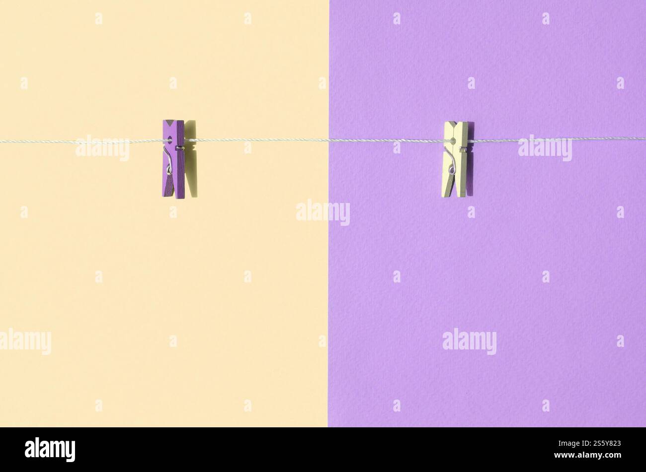 Two colored wooden pegs and small rope lie on texture background of ...