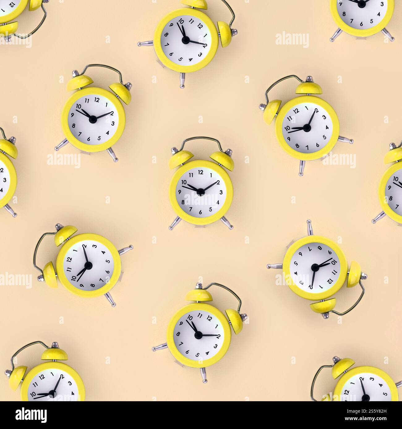 Flat lay retro beautiful new alarm clock on yellow cream color ...