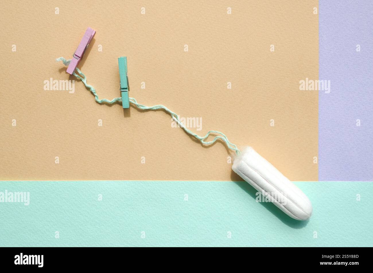 Tampon with two clothespins lie on texture background of fashion pastel ...