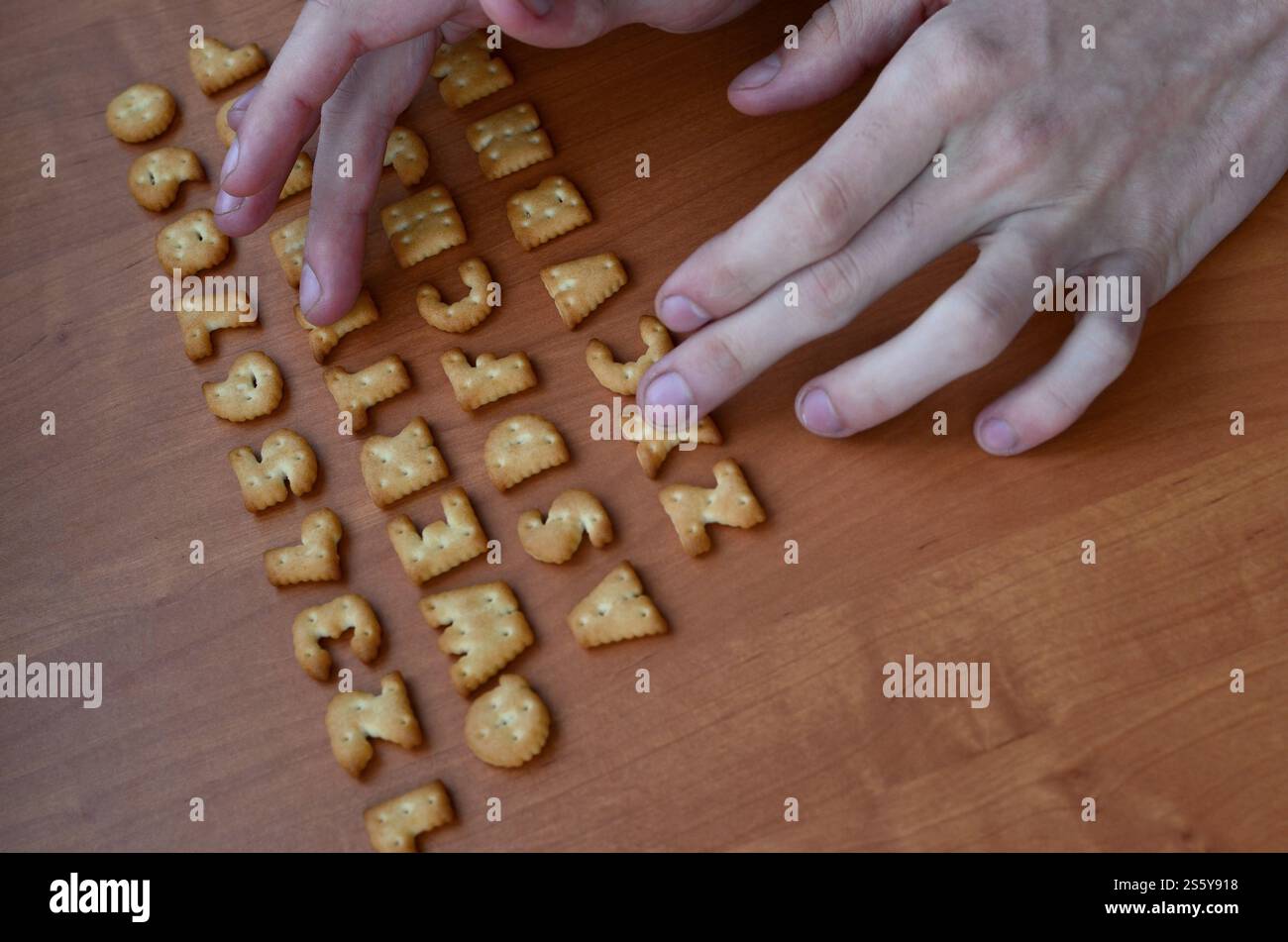 Mens Fingers Typing On The Keyboard Which Is Composed Of Salty Cracker In The Form Of Letters
