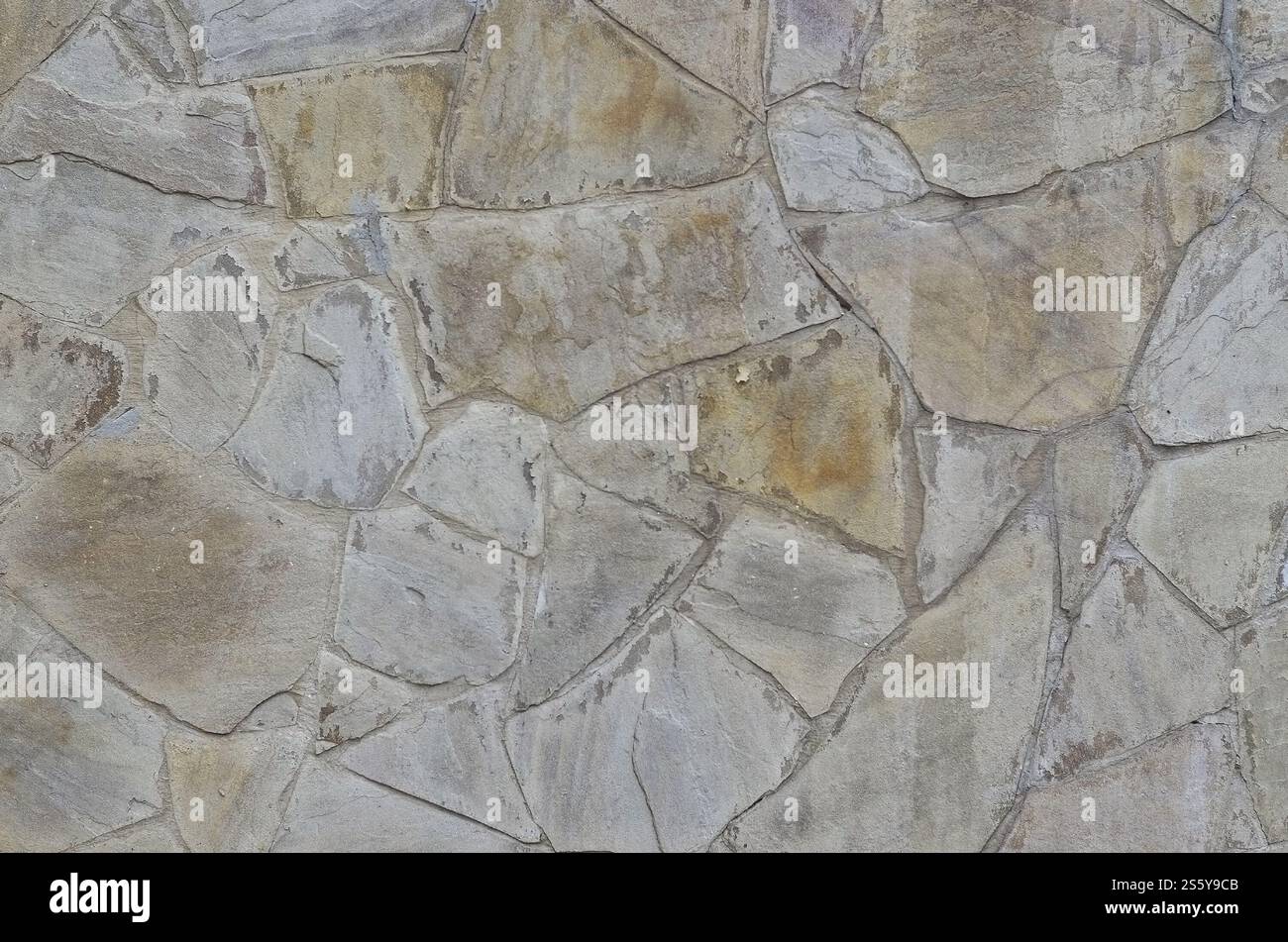 Close up of an old weathered and stained stone wall texture in daytime ...
