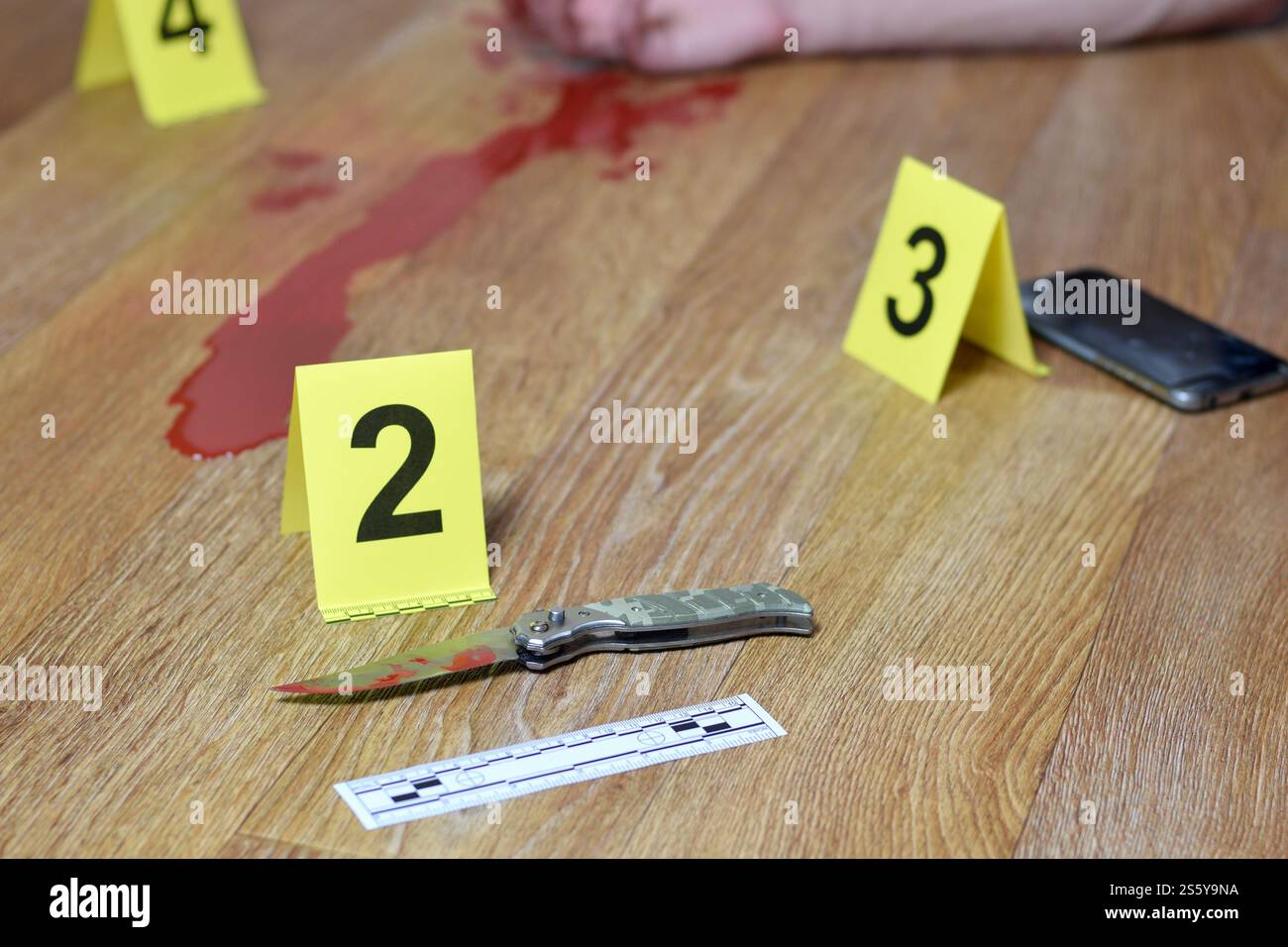 Crime scene investigation - Bloody knife and victims hand with yellow ...