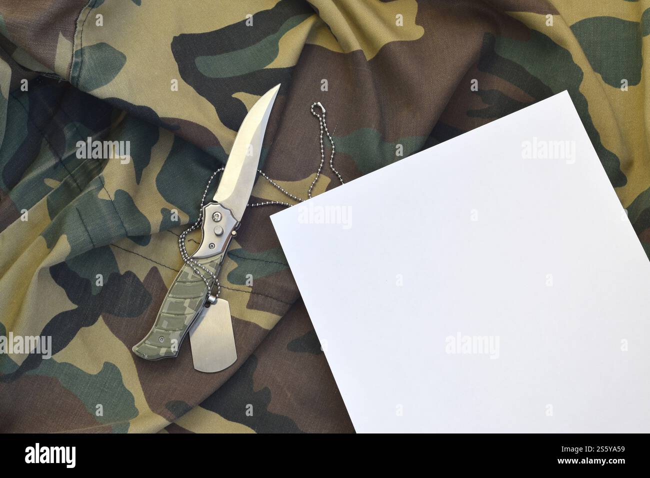 Blank paper with knife and army dog tag lies on camouflage military ...
