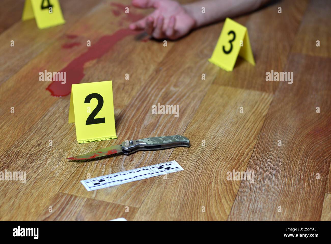 Crime scene investigation - Bloody knife and victims hand with yellow ...