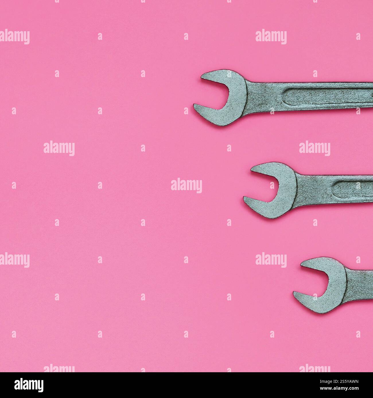 Three metallic spanners lie on texture background of fashion pastel ...
