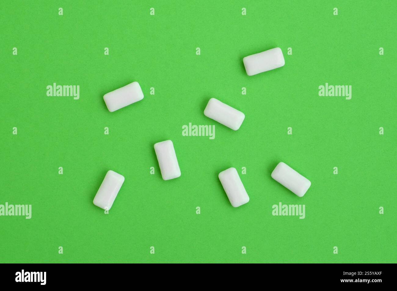 A few chewing gums lie on texture background of fashion pastel green ...