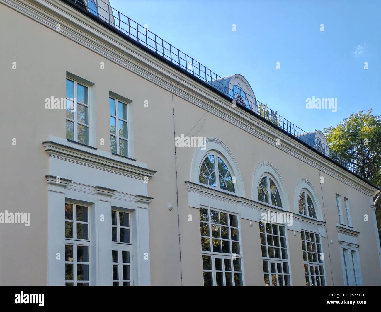 A close-up of tall rectangular windows on a beige neoclassical facade ...