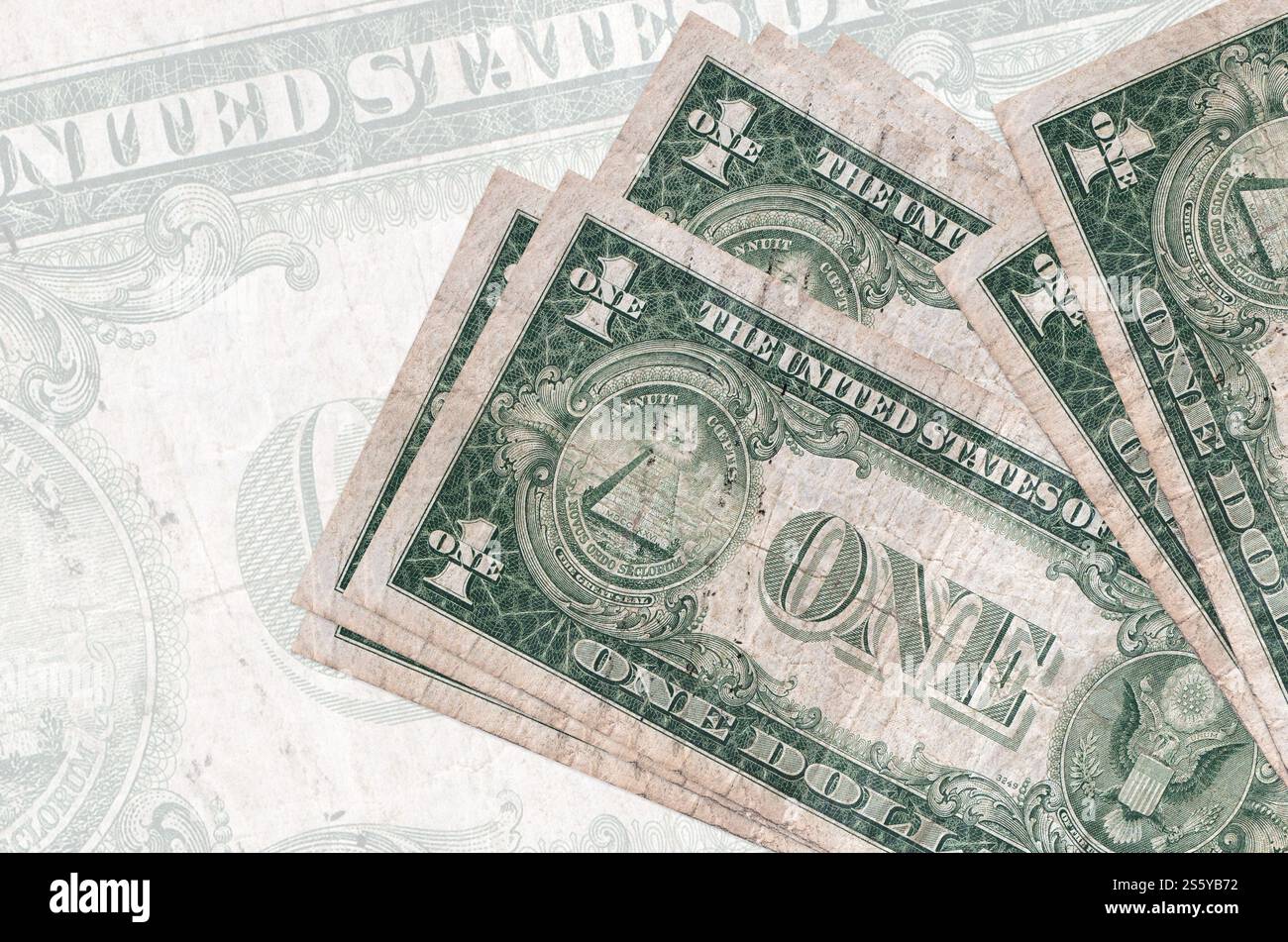 1 US dollar bills lies in stack on background of big semi-transparent ...