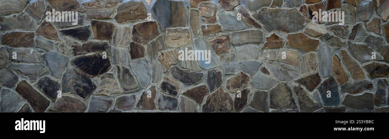 Rustic old beige brick worn foundation with shabby brown stones close ...