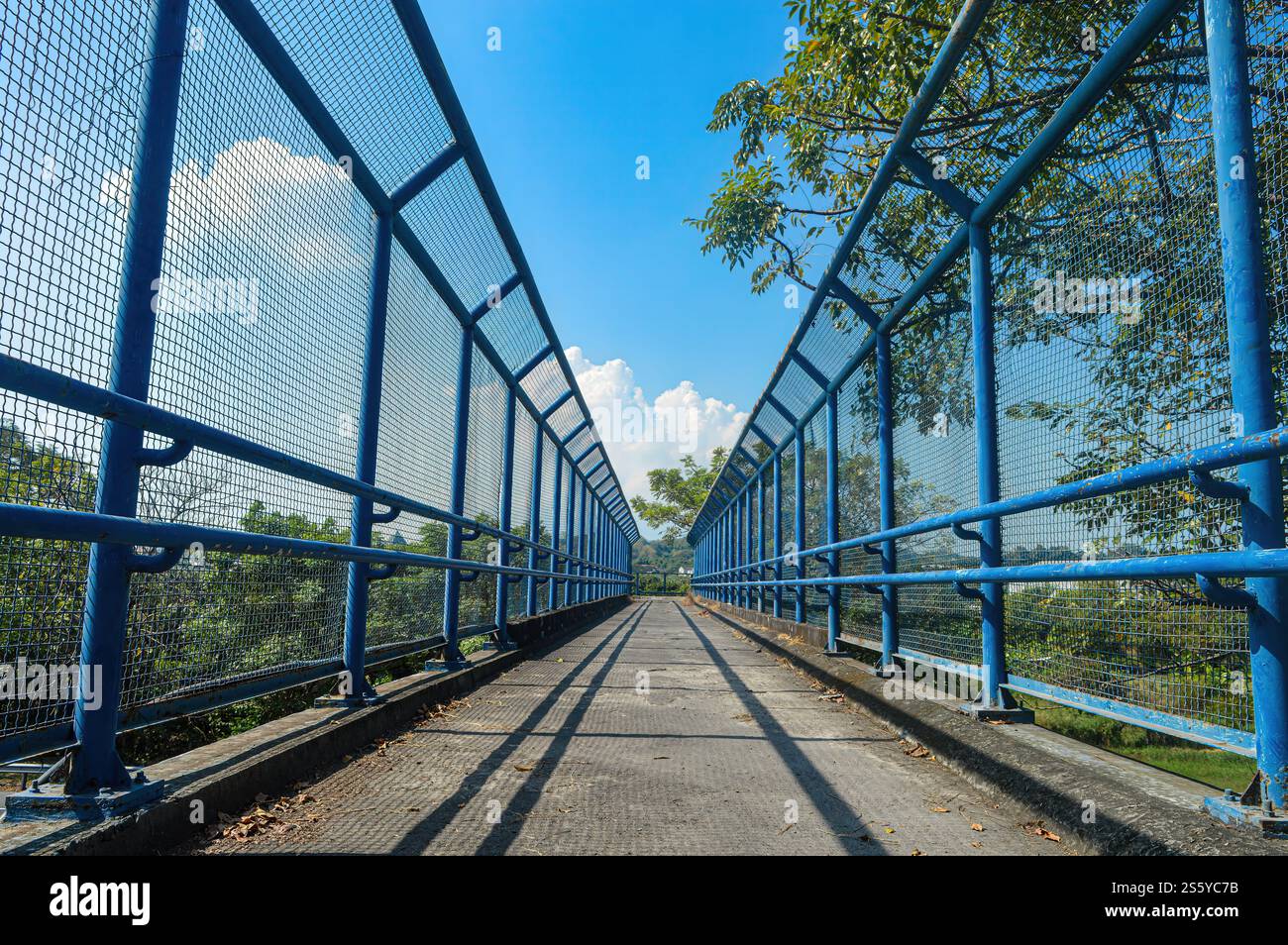 a pedestrian crossing bridge equipped with an iron mesh fence that ...