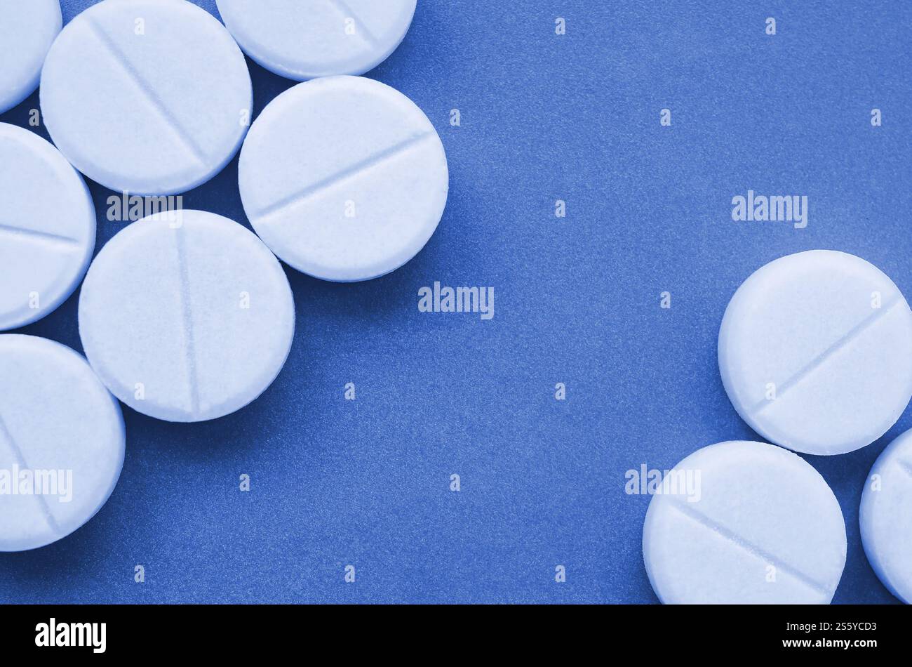 A few white tablets lie on a bright phantom classic blue color ...