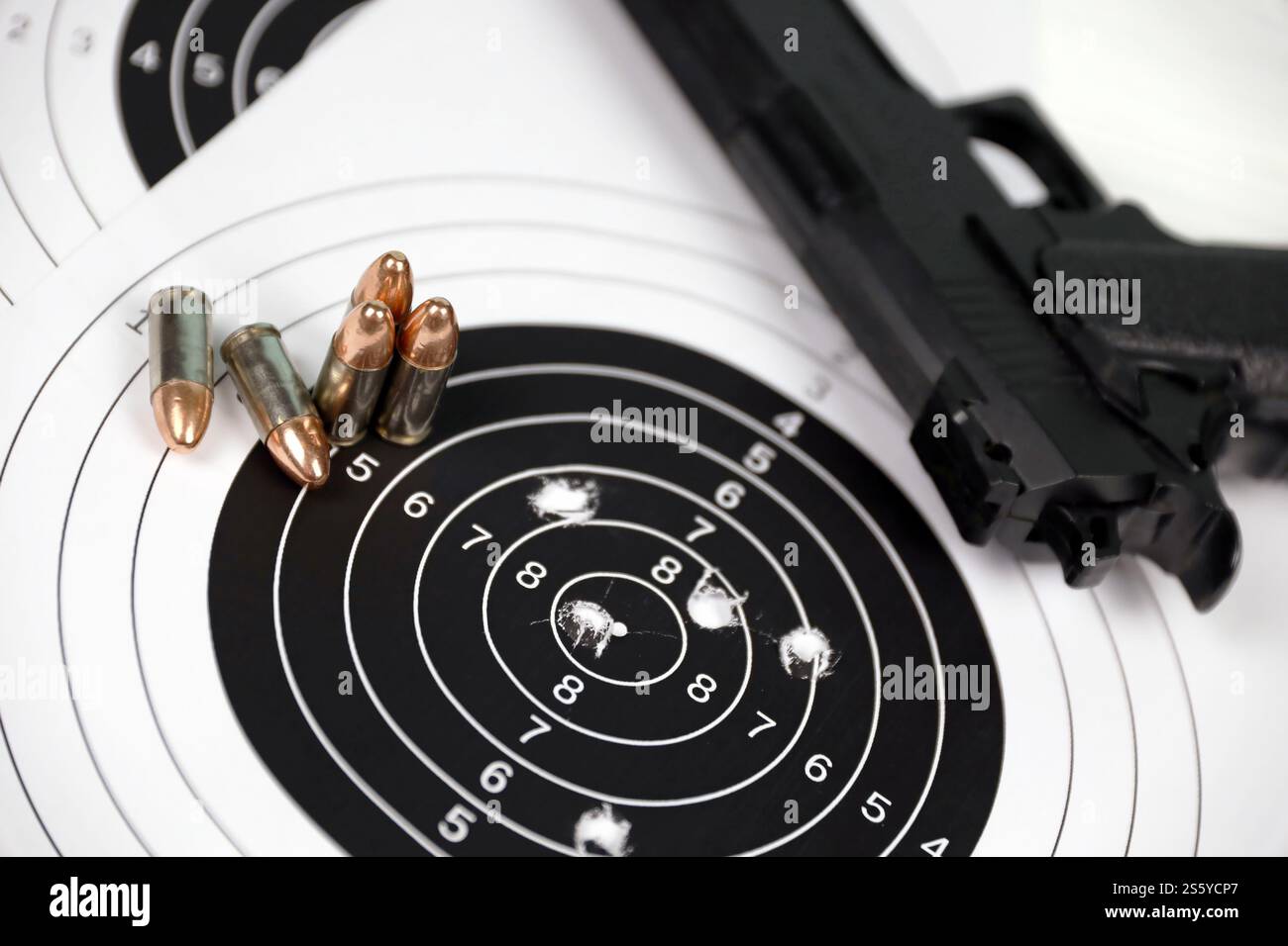 Gun and many bullets shooting targets on white table in shooting range ...