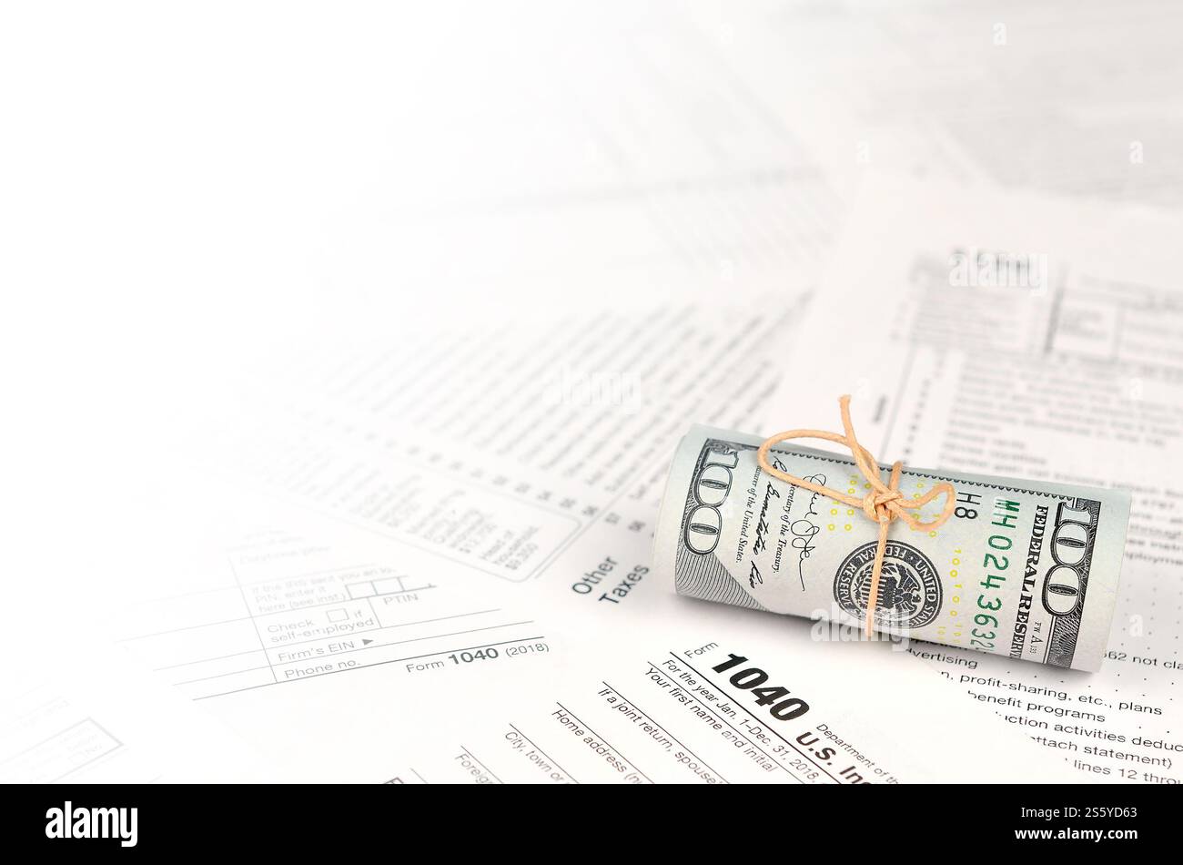 1040 Individual income tax return form with roll of american dollar ...