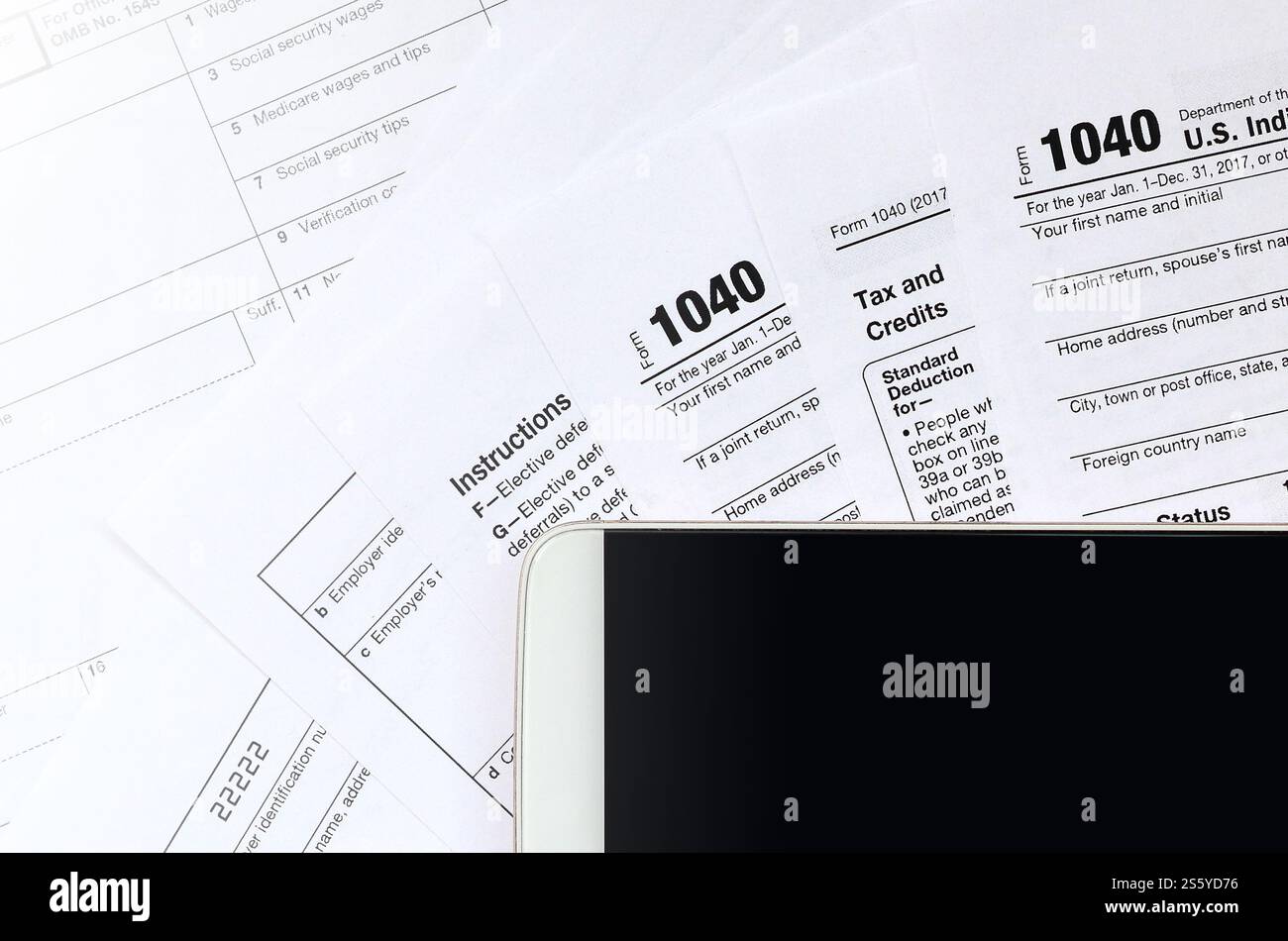 The smartphone lies on the tax form 1040 and W-2. Clean black screen ...
