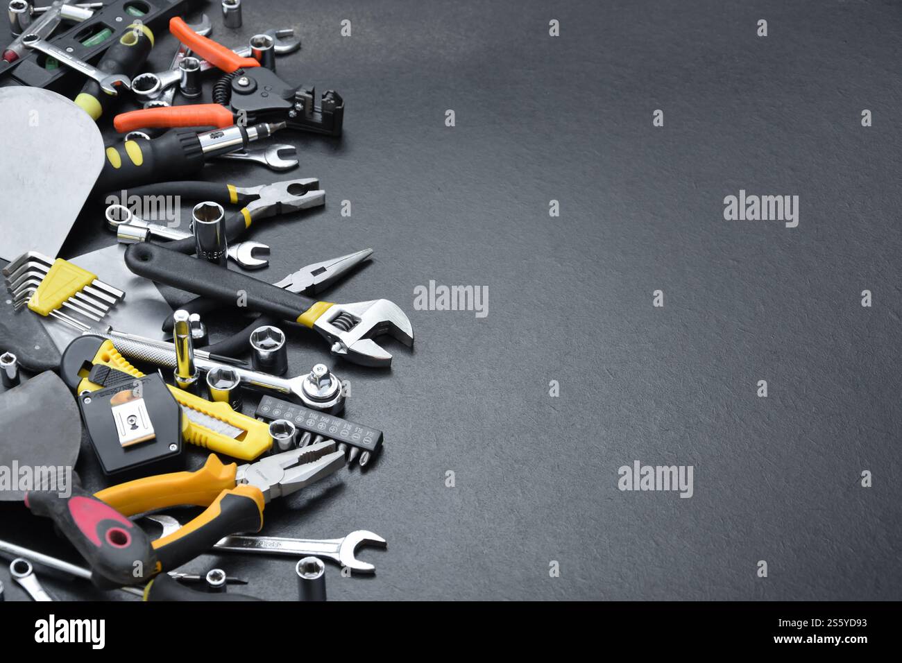 Handyman tool kit on black wooden table. Many wrenches and screwdrivers ...