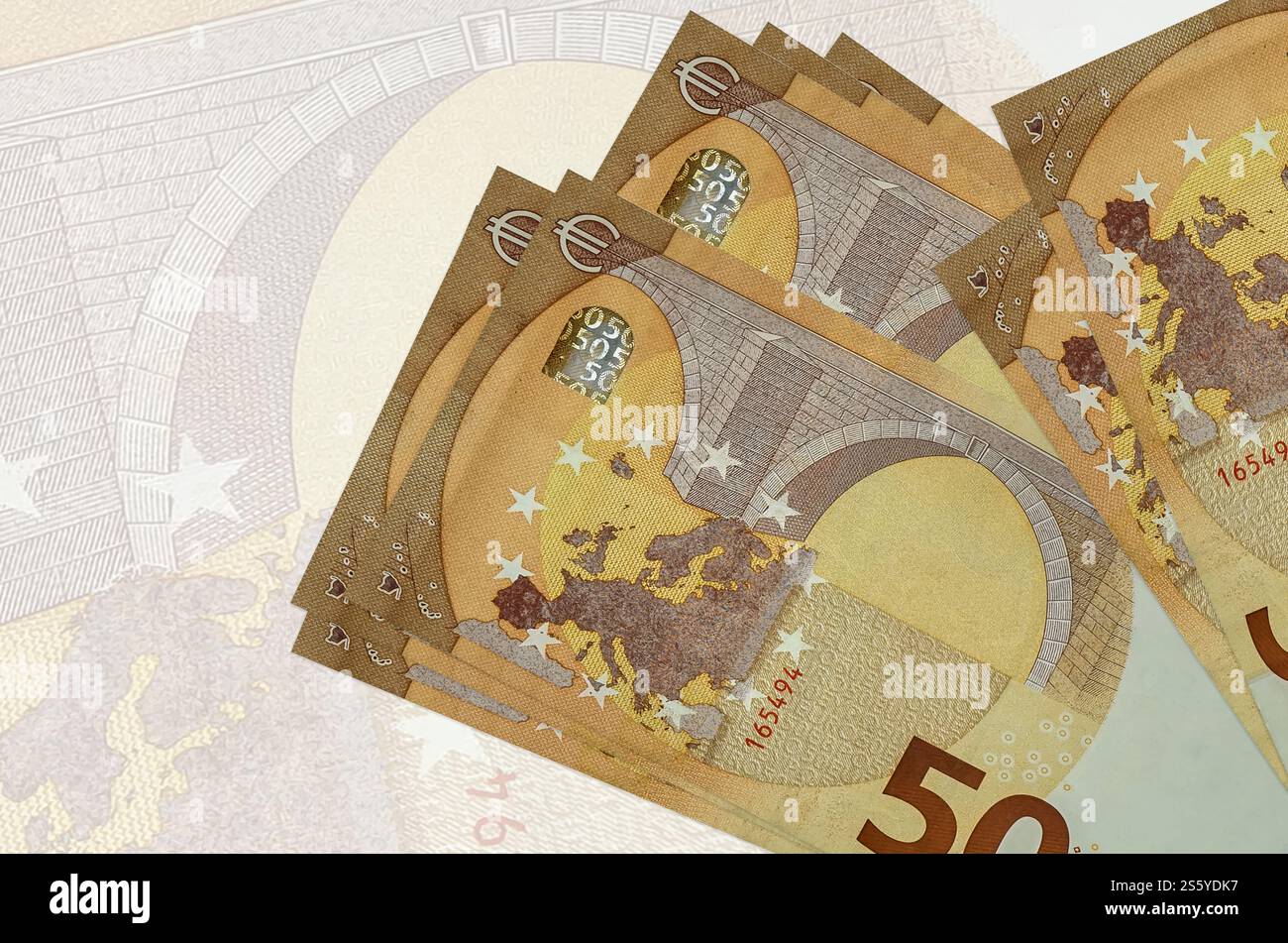 50 euro bills lies in stack on background of big semi-transparent ...