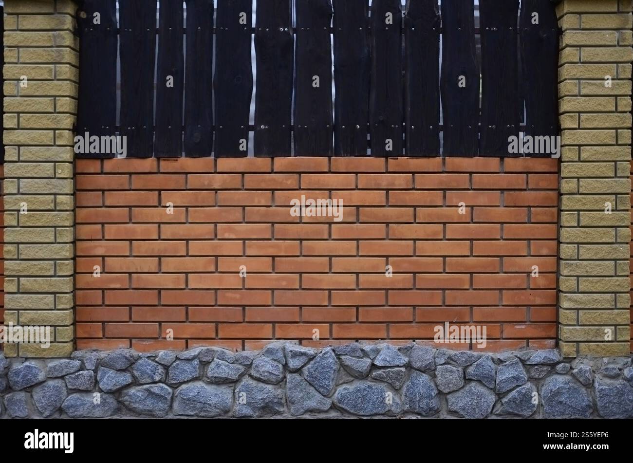 The texture of weathered wooden wall. Aged wooden plank fence of flat boards, bricks and stone ...