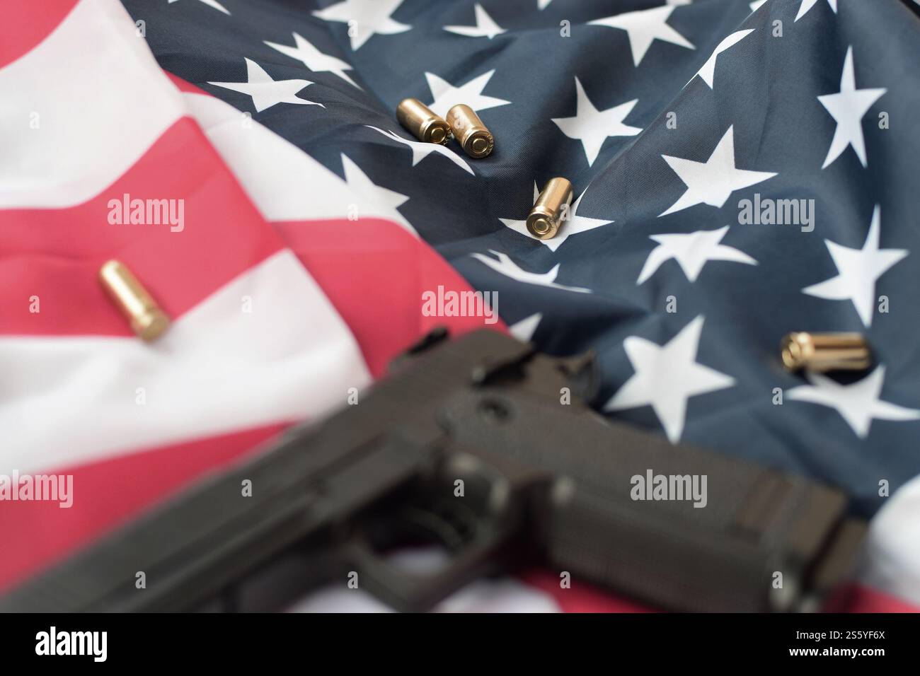 9mm bullets and pistol lie on folded United States flag. A set of self ...