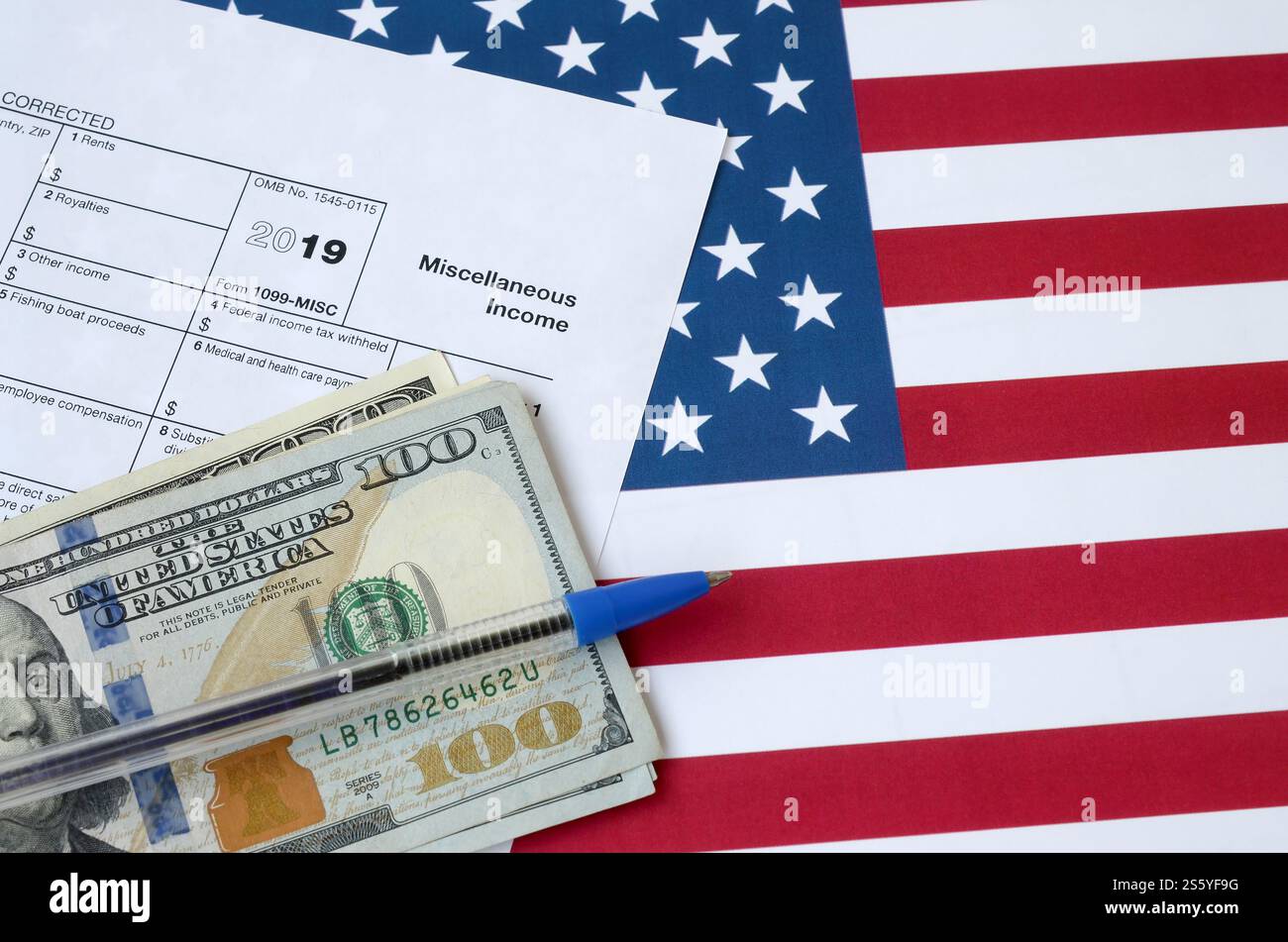 Form 1099-misc Miscellaneous income and blue pen with dollar bills lies ...