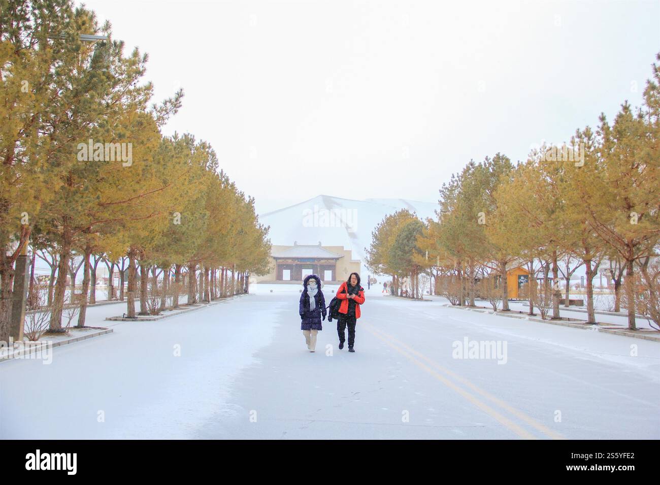 Tourists admire the snow scenery of the Mingsha Mountain and Yueya ...