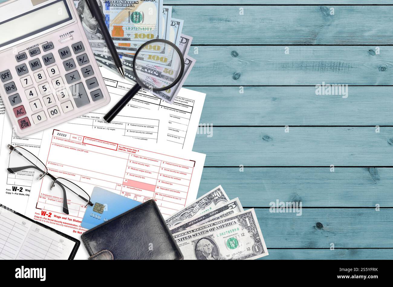 IRS form W-2 wage and tax statement lies on flat lay office table and ...