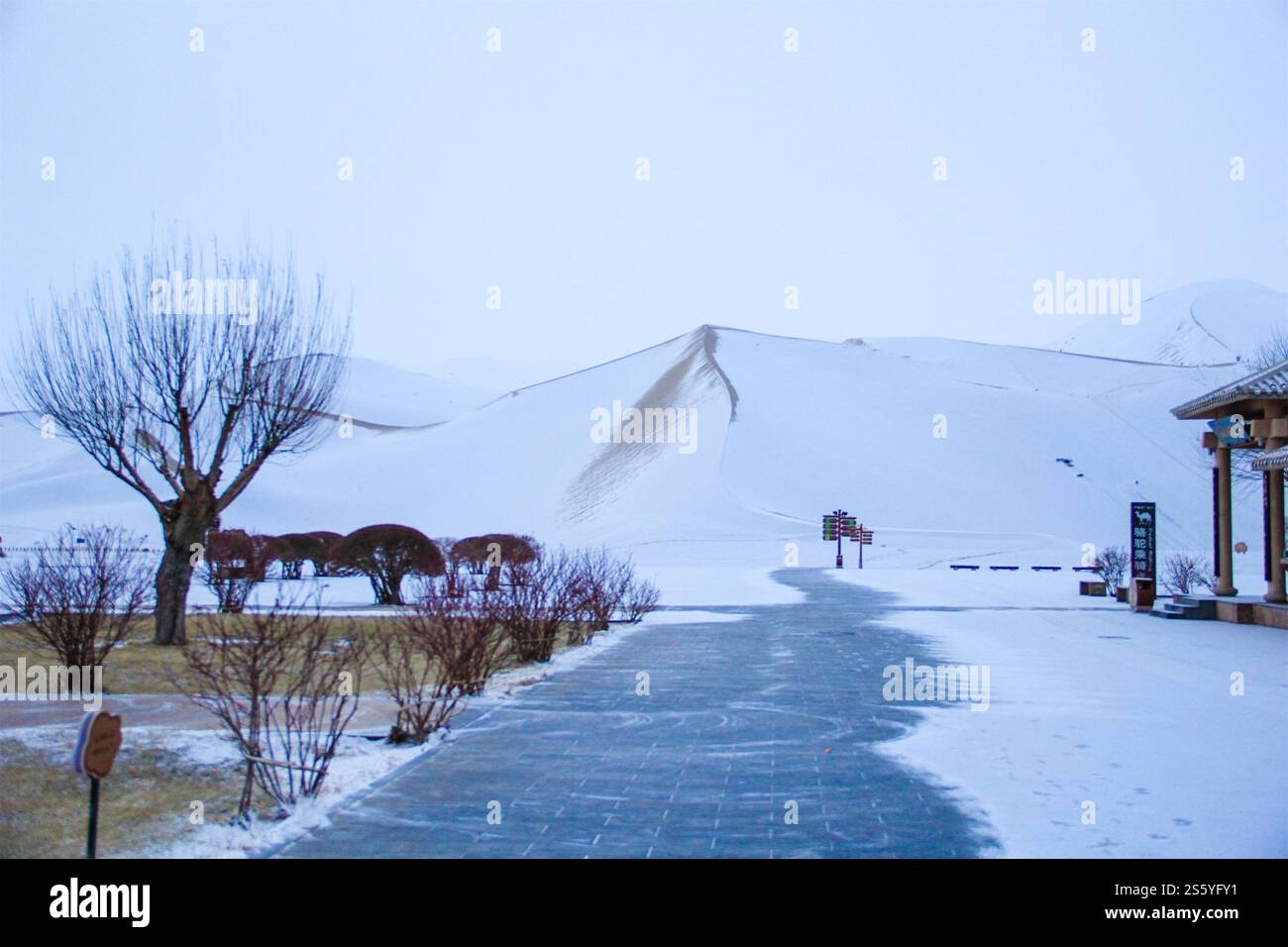 Tourists admire the snow scenery of the Mingsha Mountain and Yueya ...