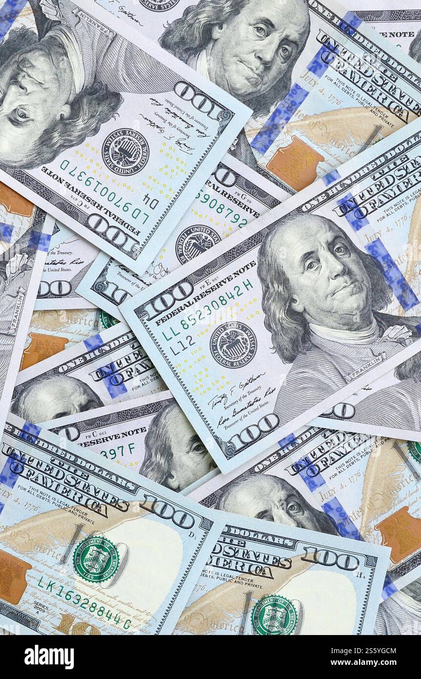 A large number of US dollar bills of a new design with a blue stripe in ...