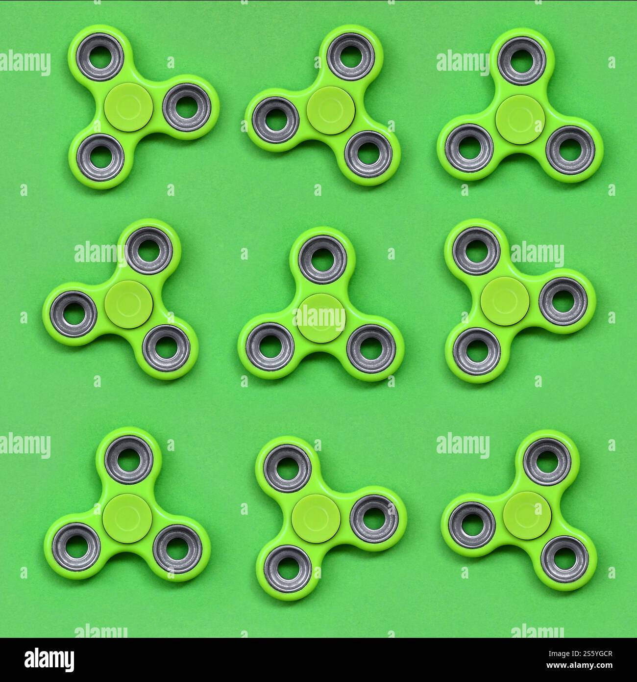 Many green fidget spinners lies on texture background of fashion pastel ...