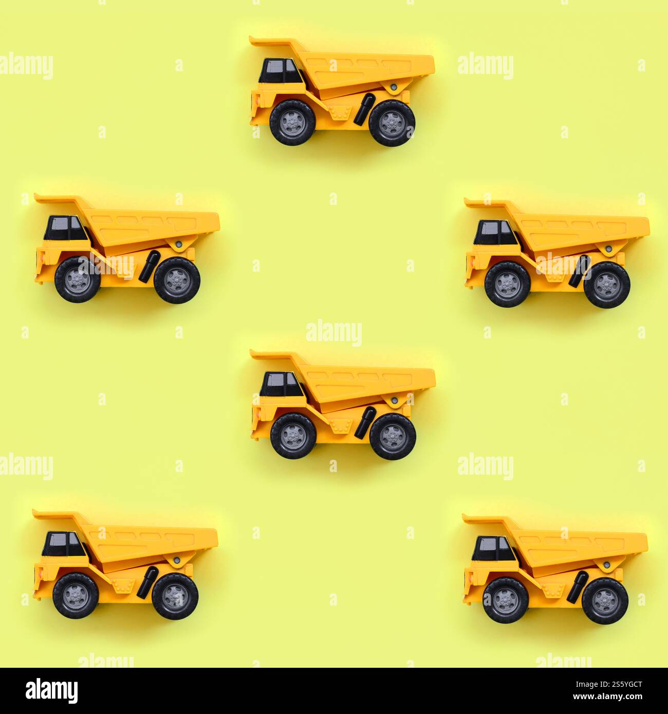 Many small yellow toy trucks on texture background of fashion pastel ...