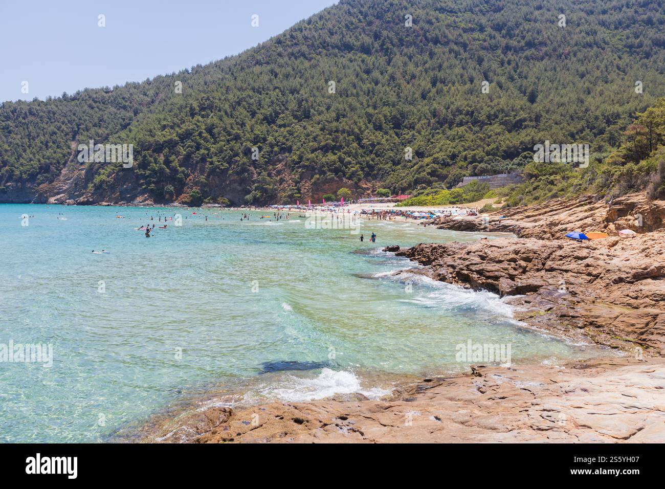 A rocky beach in Greece with crystal-clear waters. The rugged coastline ...