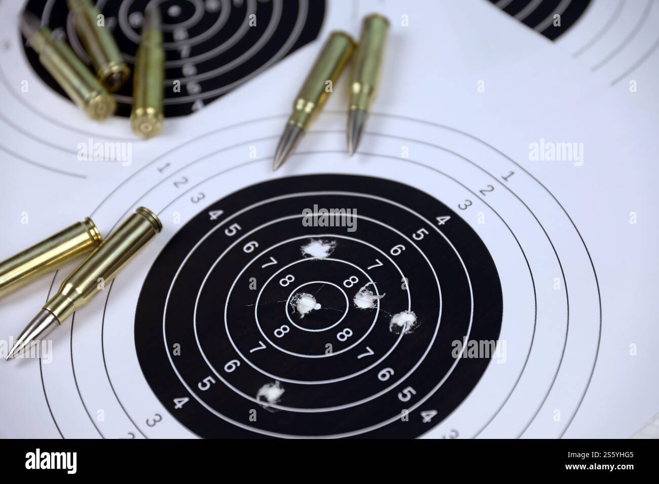 Many bullets with shooting targets on white table in shooting range ...