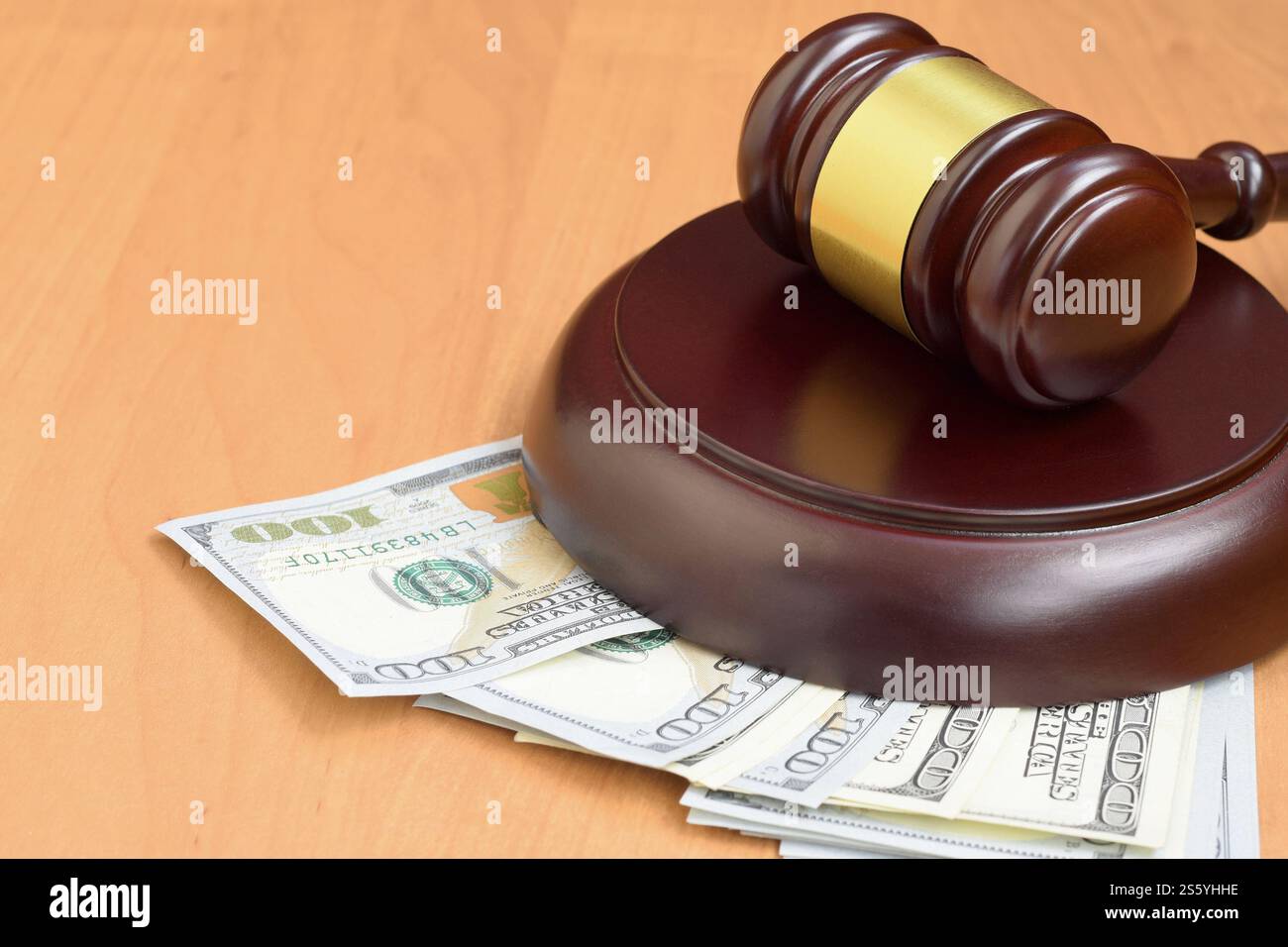 Judge gavel and money on brown wooden table. Many hundred dollar bills ...