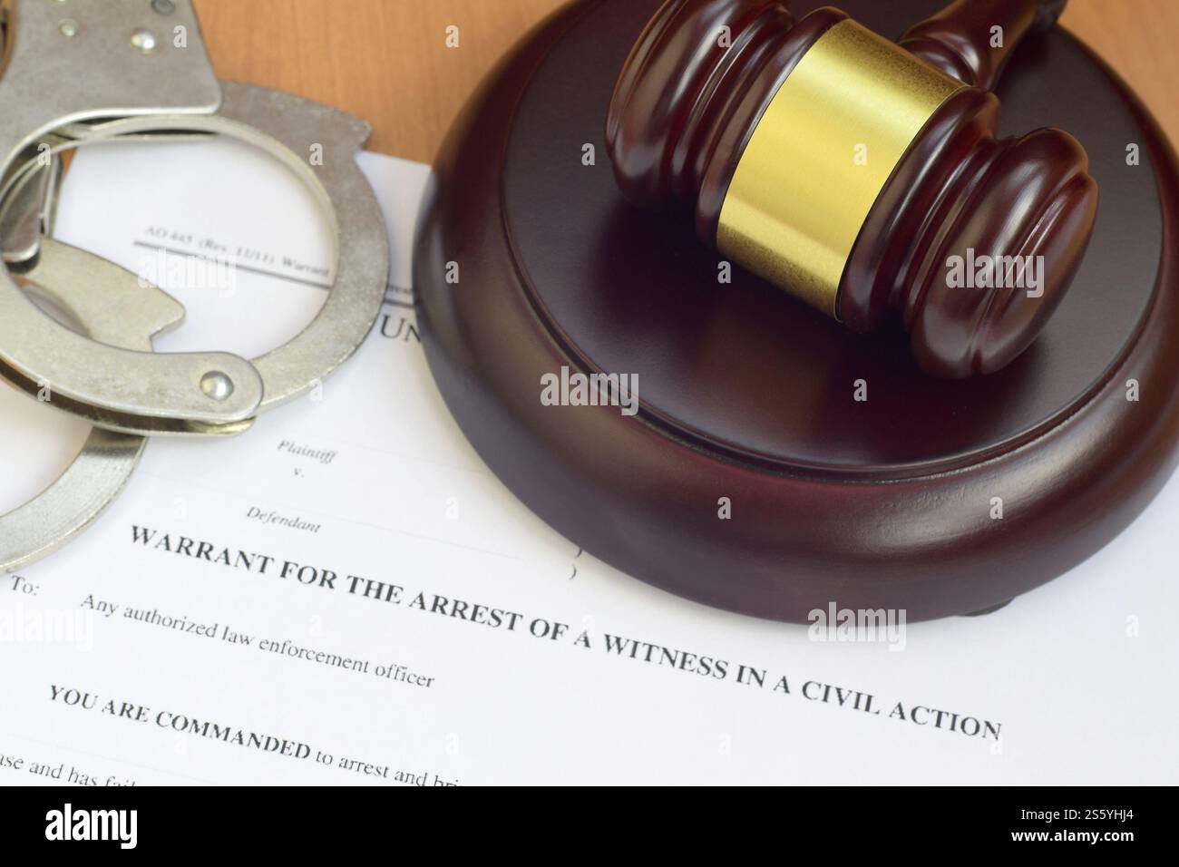 Justice mallet and Warrant for the arrest of a witness in a civil action with police handcuffs ...