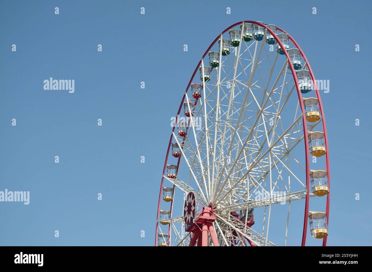 Big and modern multicolour ferris wheel on clean blue sky background ...