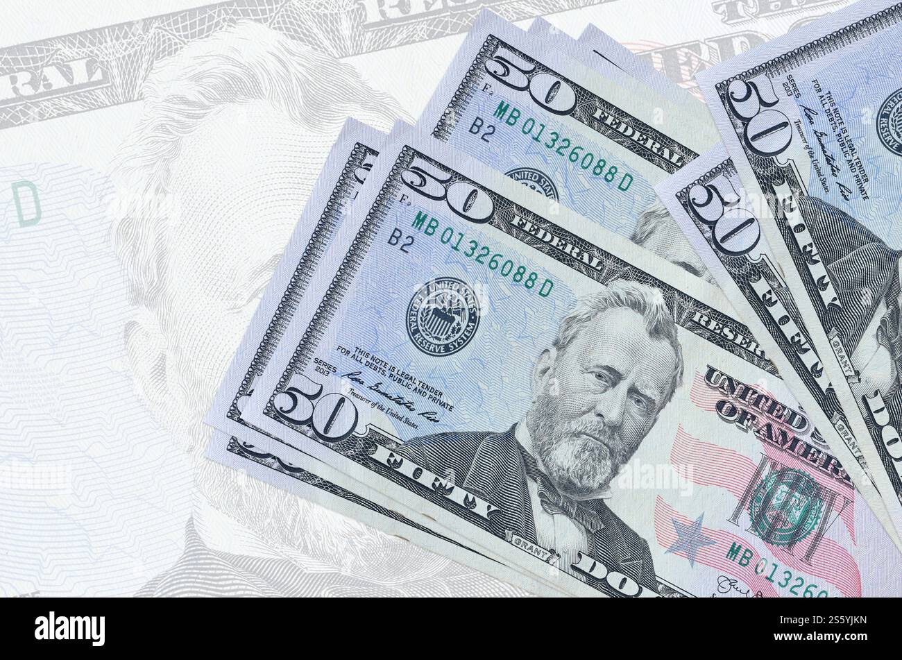 50 US dollars bills lies in stack on background of big semi-transparent ...