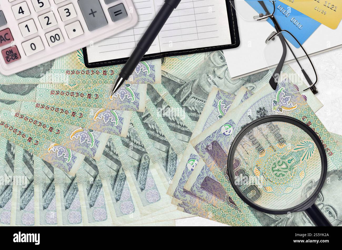 20 Thai Baht bills and calculator with glasses and pen. Tax payment ...