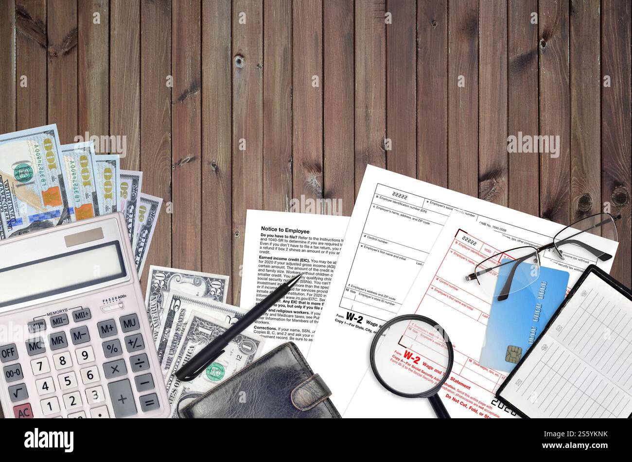 IRS form W-2 wage and tax statement lies on flat lay office table and ...