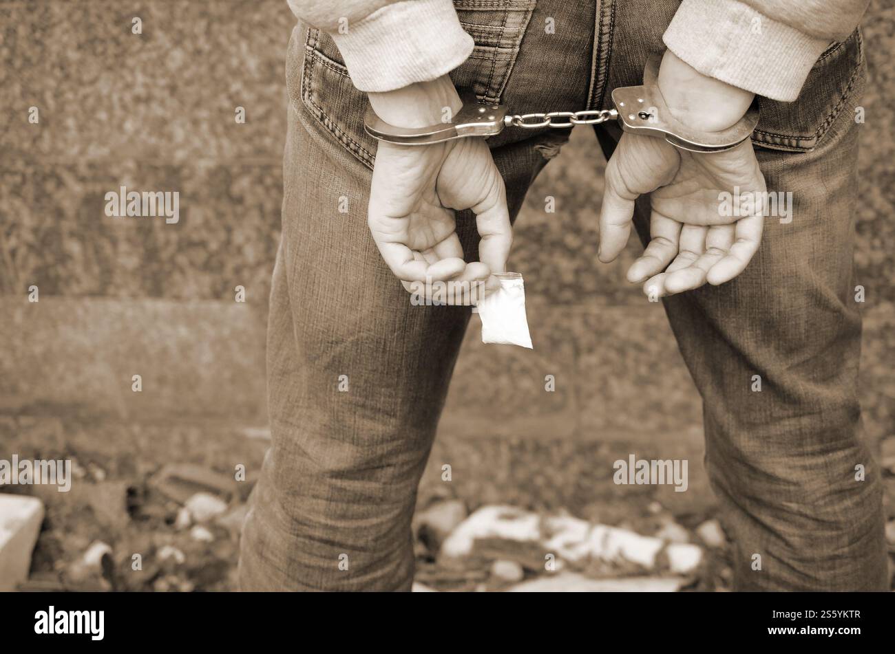 Arrested drug dealer in handcuffs with small heroin drug package on ...