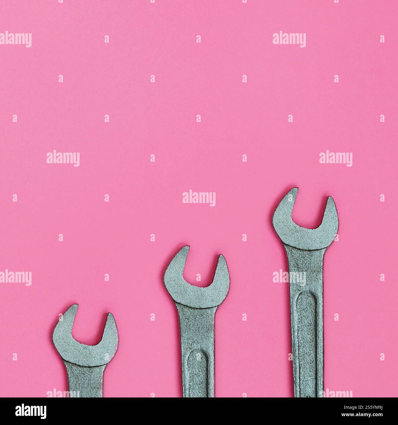 Three metallic spanners lie on texture background of fashion pastel ...
