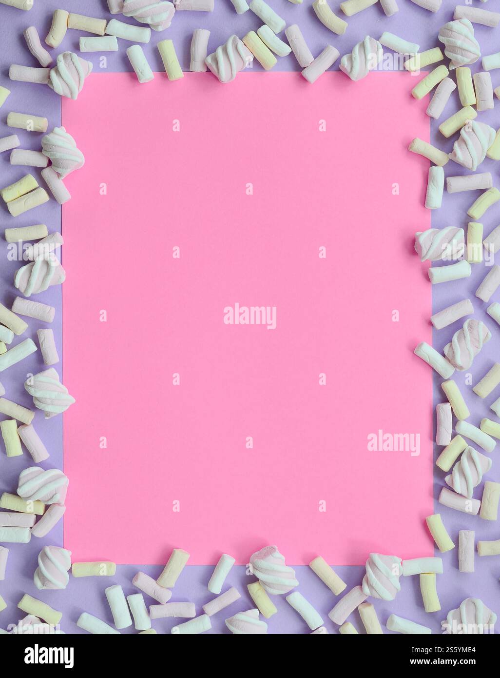 Colorful marshmallow laid out on violet and pink paper background ...