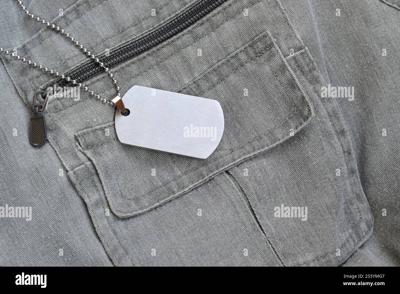 Silvery military beads with dog tag on dark grey vest with pockets ...