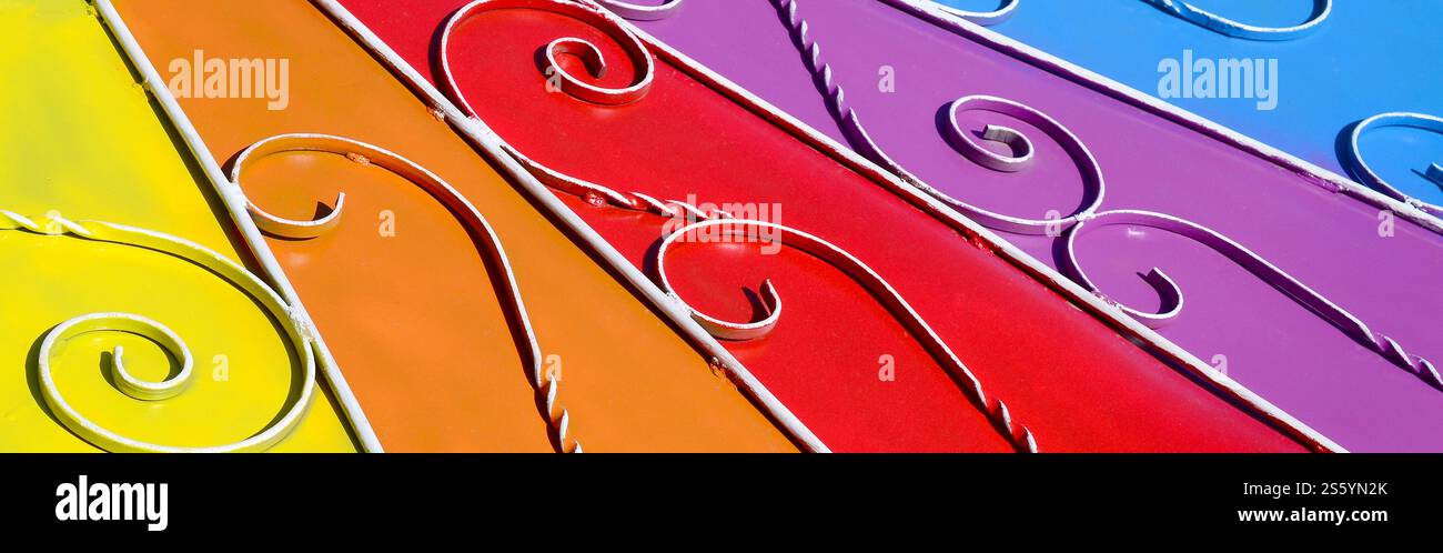 Metal texture of a piece of colored wall with a forged pattern. Rainbow ...