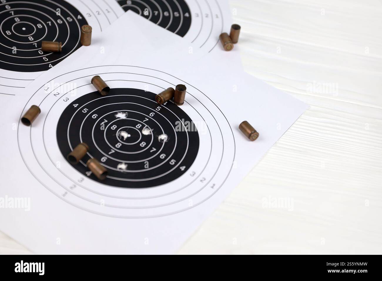 Many bullets with shooting targets on white table in shooting range ...
