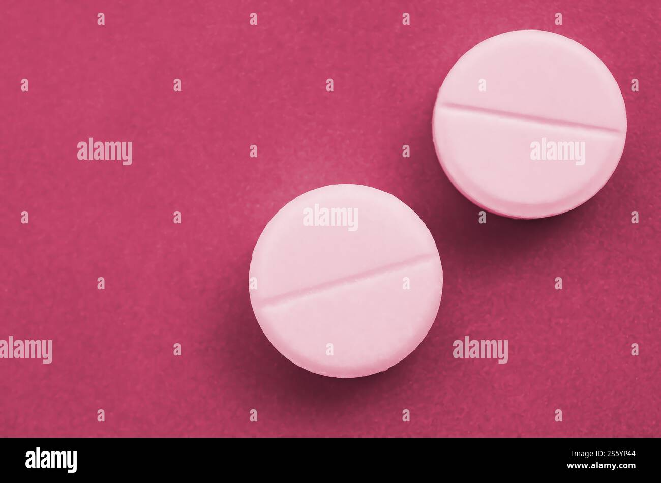 A few white tablets lie on a bright background surface. Background ...