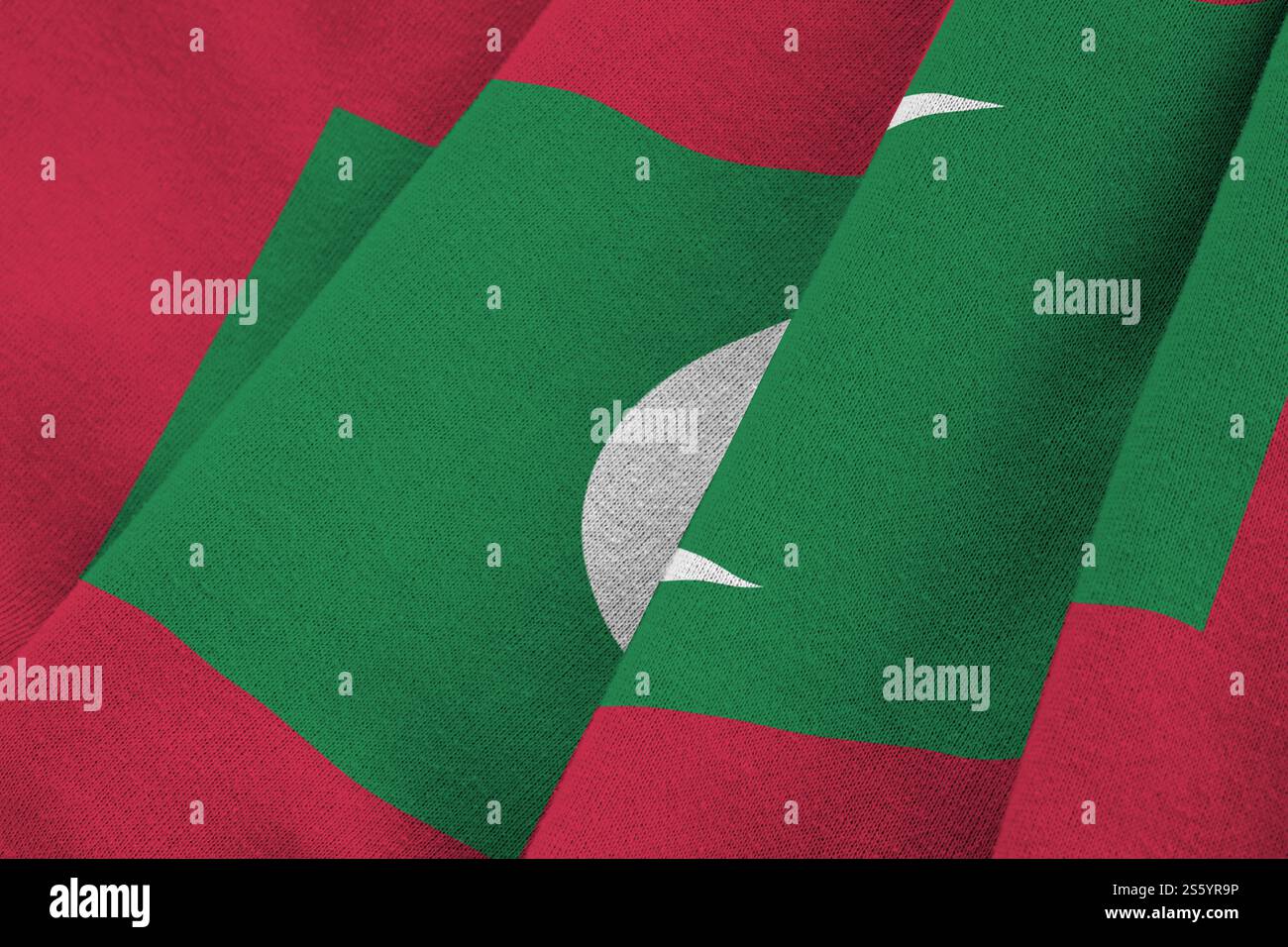 Maldives flag with big folds waving close up under the studio light ...