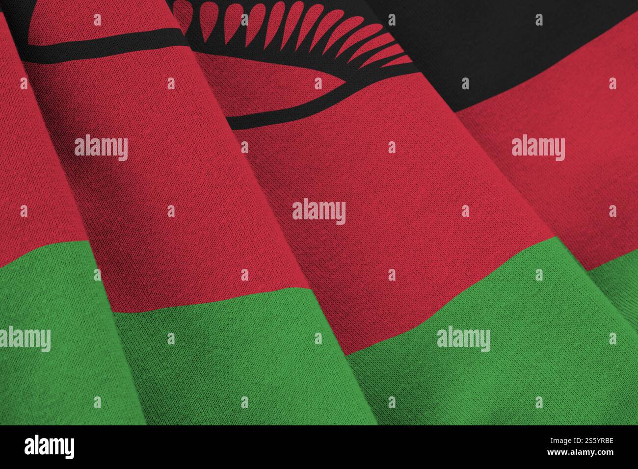 Malawi flag with big folds waving close up under the studio light ...
